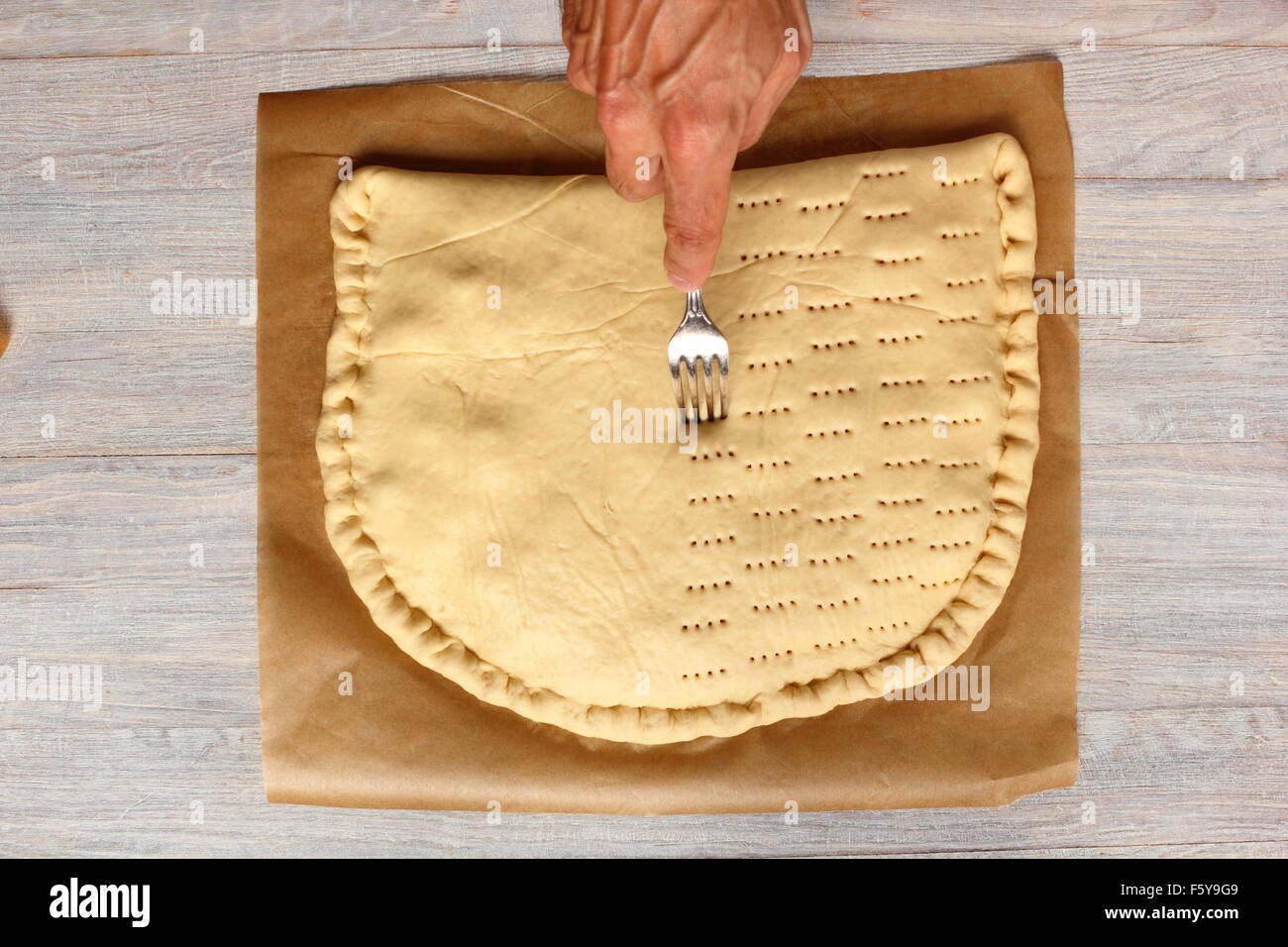Pricking dough with fork. Making Meat Pie from Yeast Dough Stock Photo ...