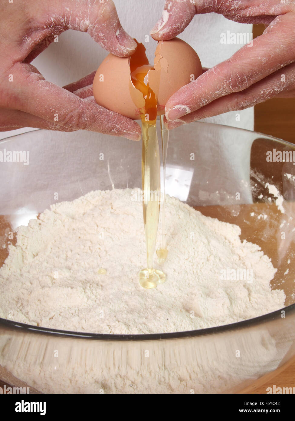 Cracking egg. Making Chocolate Layer Cake with Cream Cheese Filling and ...