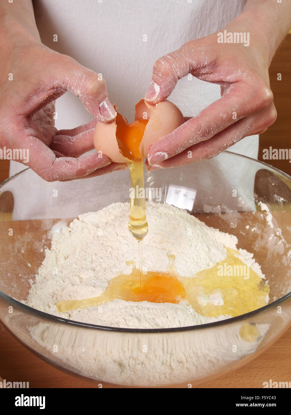 Cracking egg. Making Chocolate Layer Cake with Cream Cheese Filling and ...