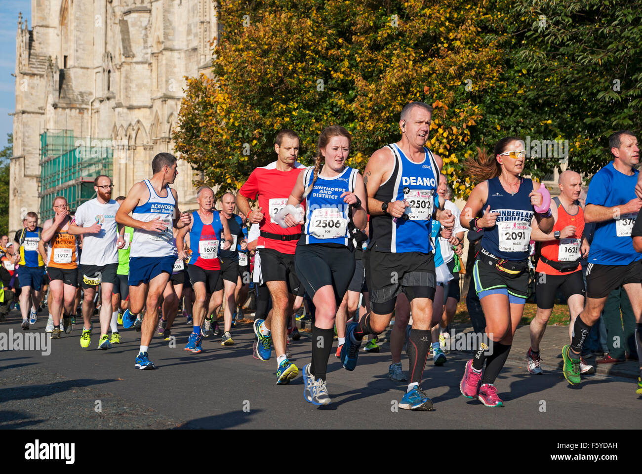 People running runners racing through the city town centre in the ...