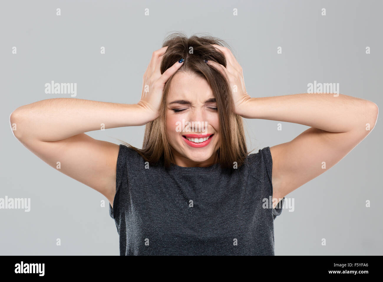 Portrait of a young woman with depressed expression standing isolated ...