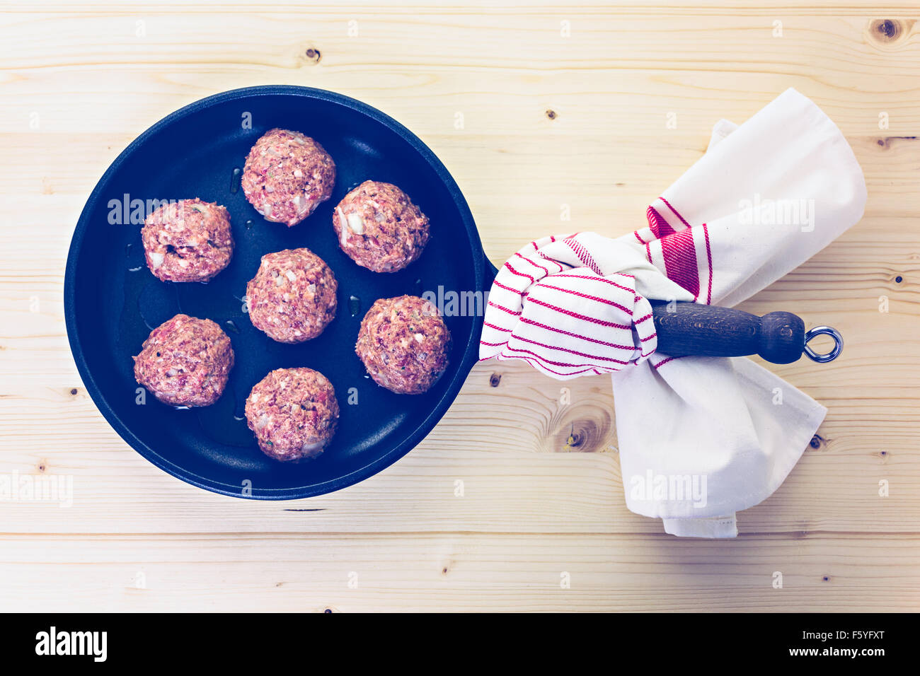 Frying large homemade Italian meatballs on a midium frying pan for ...
