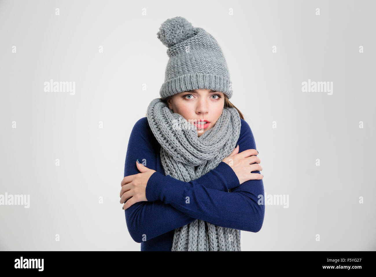Portrait of a freezing woman in winter cloth standing isolated on a ...