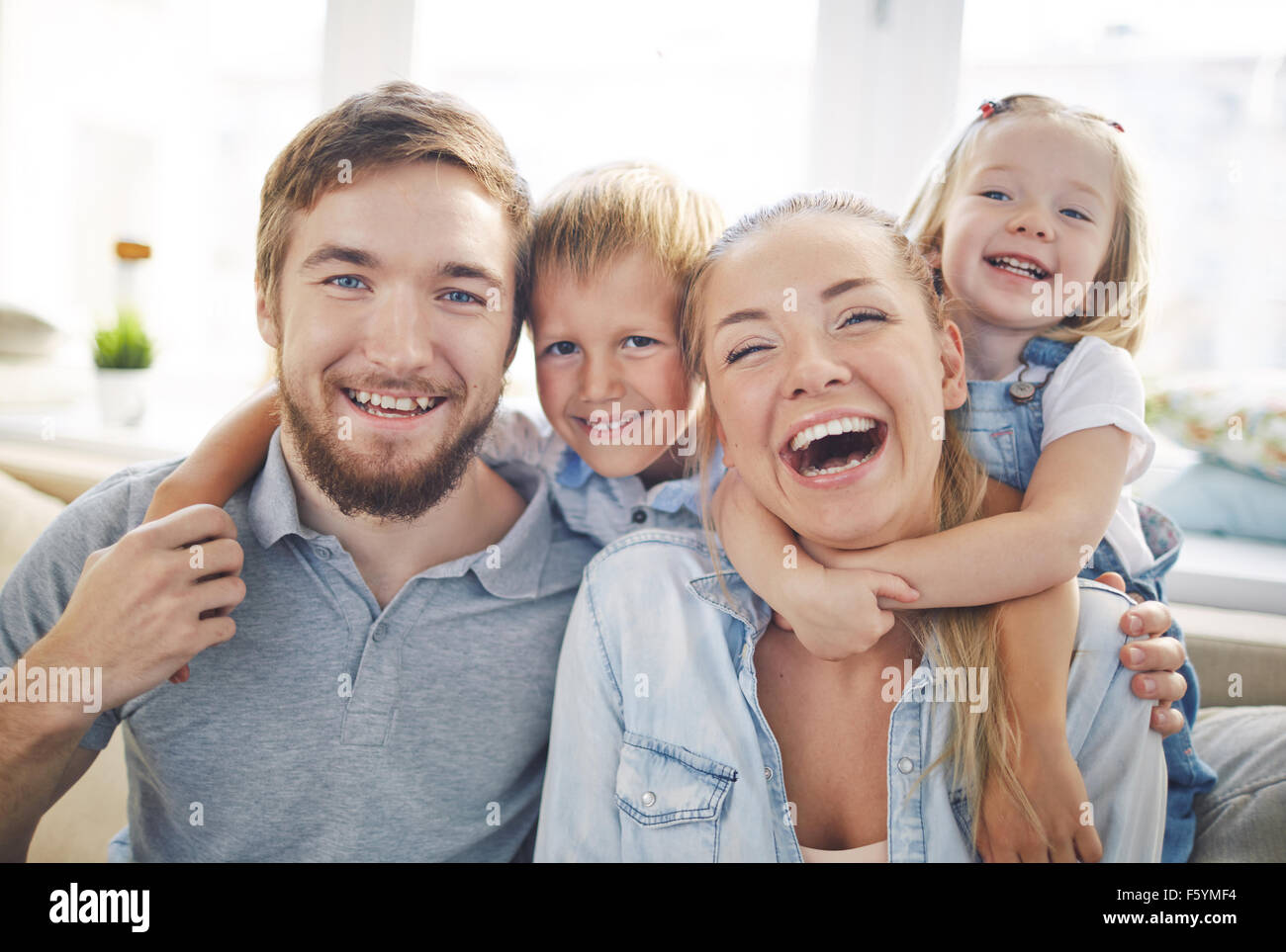 Happy young parents and their two kids Stock Photo - Alamy