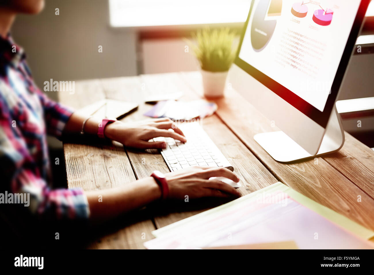 Young woman sitting in front of computer screen Stock Photo - Alamy