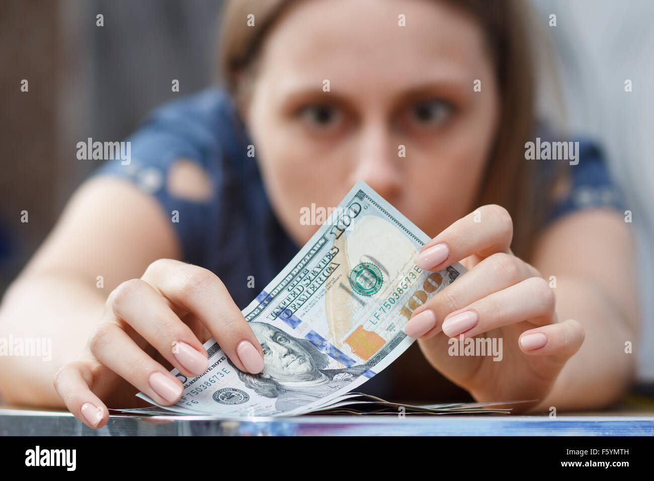 Young happy woman count dollars on the table Stock Photo - Alamy
