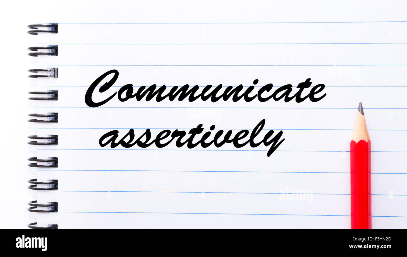 Communicate Assertively written on notebook page, red pencil on the ...