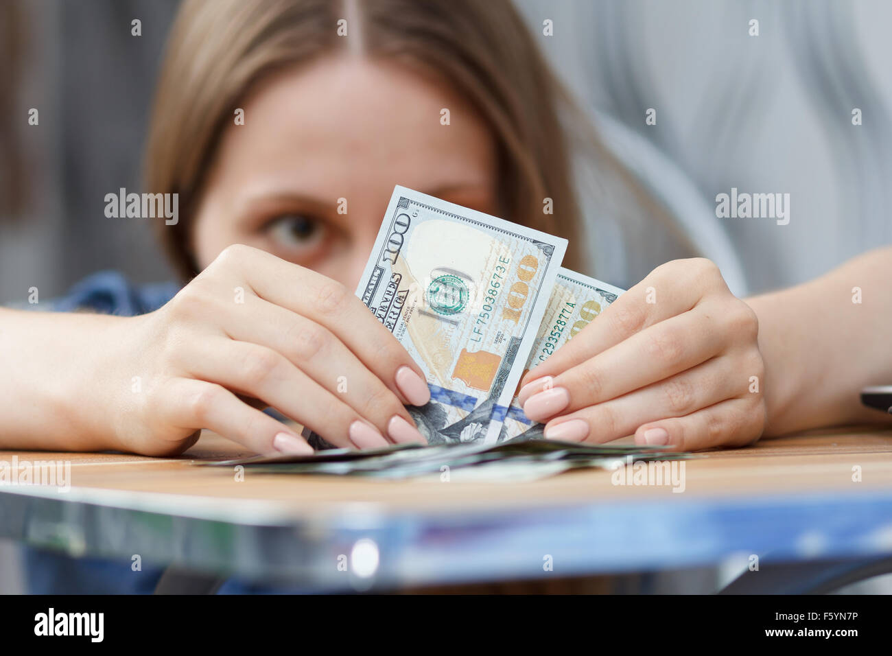 Young happy woman count dollars on the table Stock Photo - Alamy
