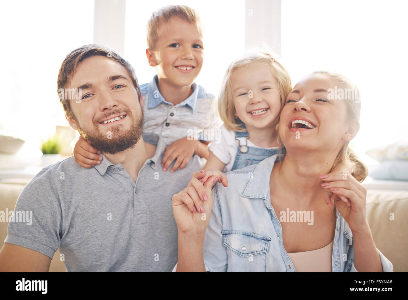 Joyful parents and their cute kids laughing Stock Photo - Alamy