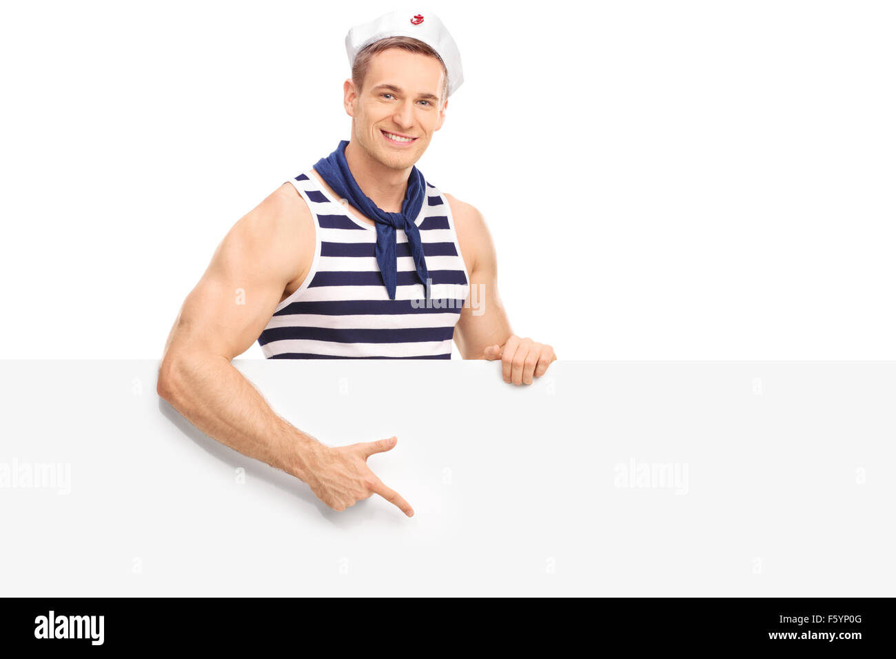 Young male sailor pointing on a blank signboard with his finger and ...