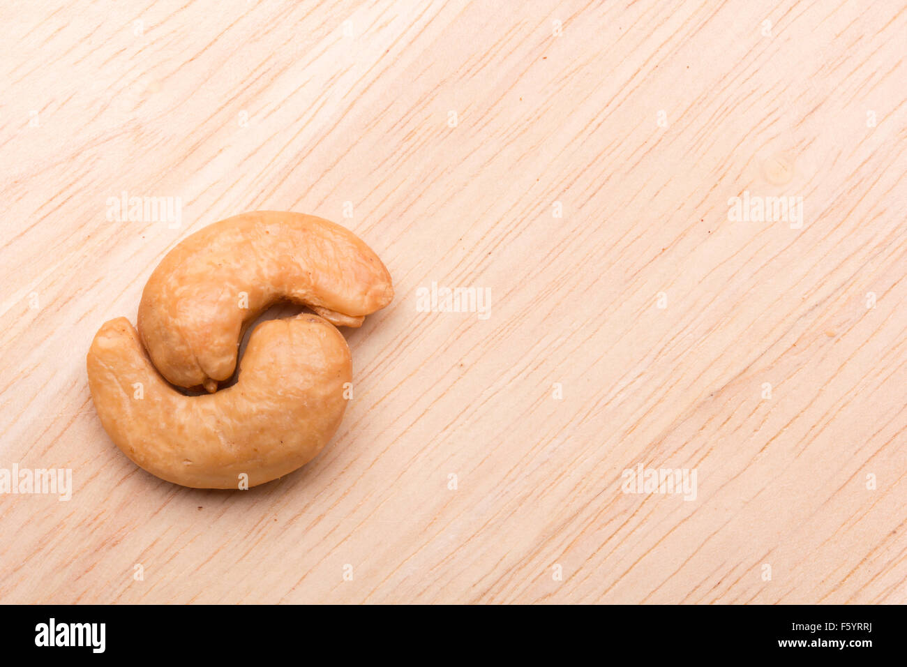 two cashew nuts on wood background with copy space Stock Photo - Alamy