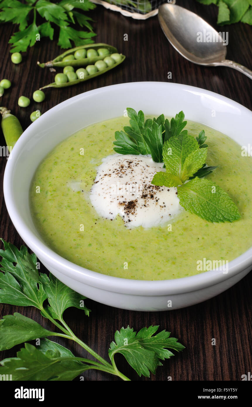 Portion cream soup with green peas with mint cream Stock Photo - Alamy