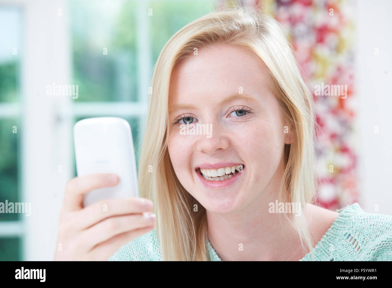 Smiling Young Woman Reading Text Message Stock Photo - Alamy