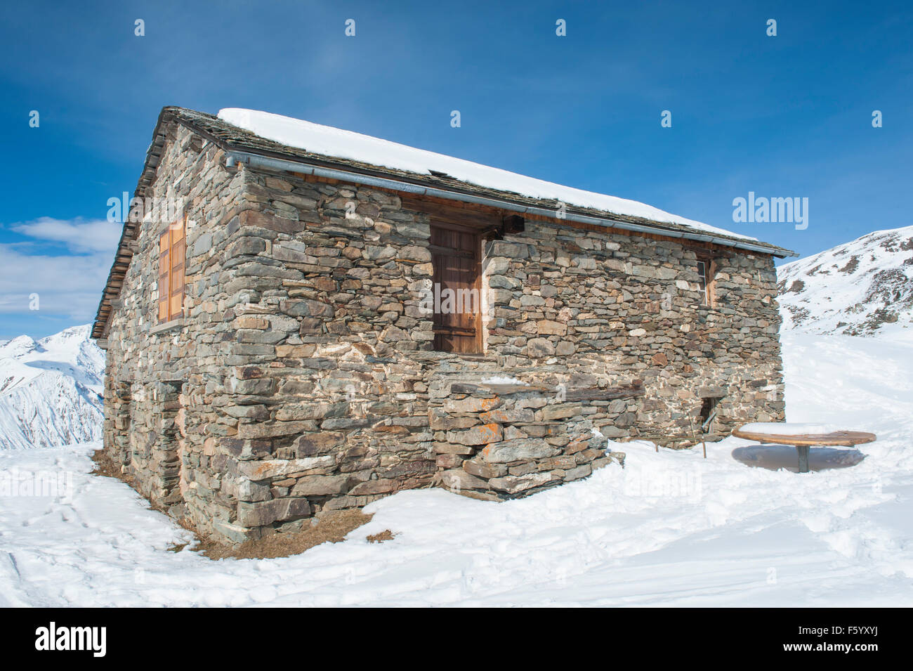 Remote stone mountain hut on an alpine slope covered in snow Stock ...