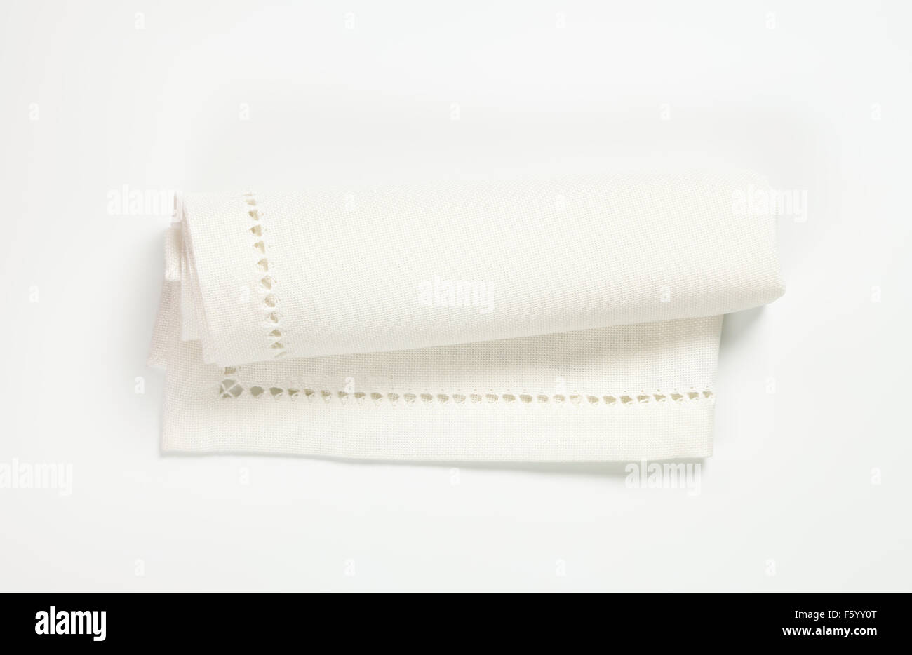 rolled up white place mat on white background Stock Photo - Alamy