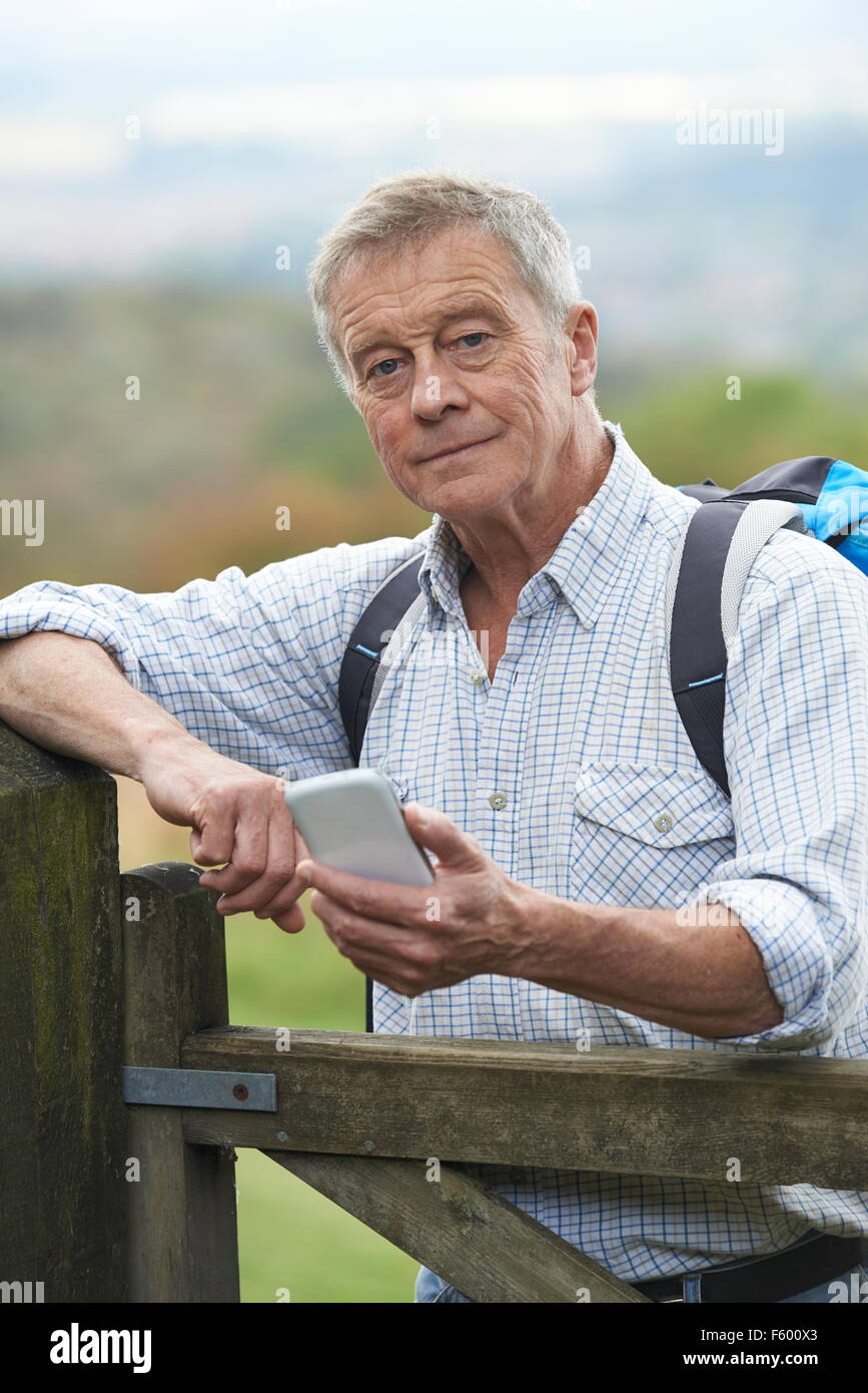 Senior Man Checking Location With Mobile Phone On Hike Stock Photo - Alamy