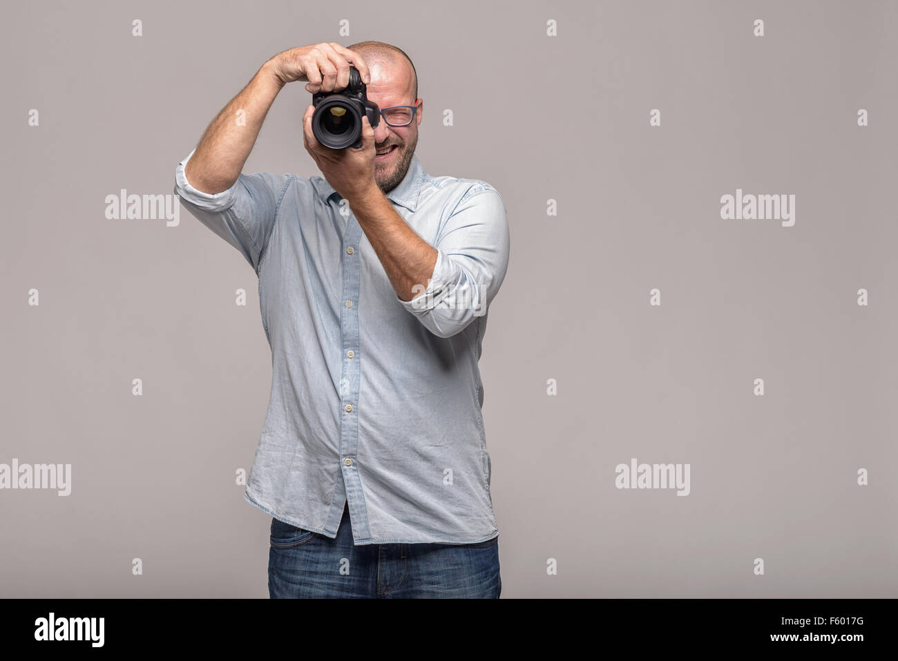 Male photographer focusing and composing an image with his professional ...