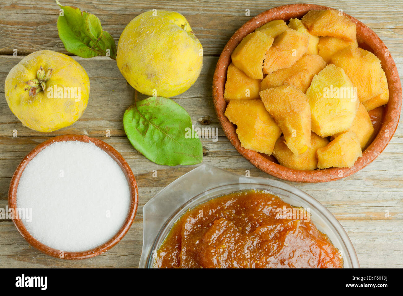 Spanish quince fruits and paste with ingredients on wooden background ...