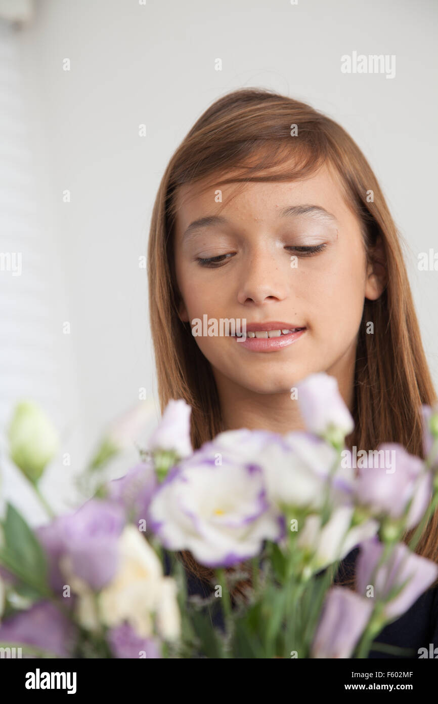 Pretty girl smelling the flowers Stock Photo - Alamy