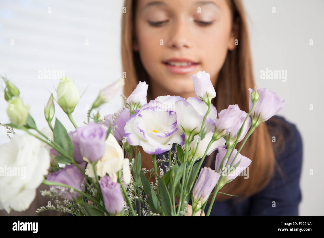 Pretty girl smelling the flowers Stock Photo - Alamy
