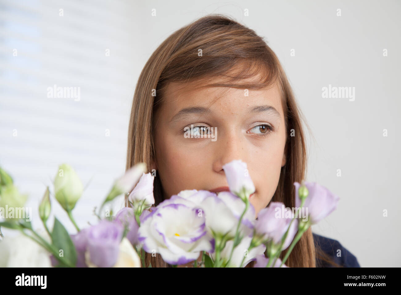Pretty girl smelling the flowers Stock Photo - Alamy