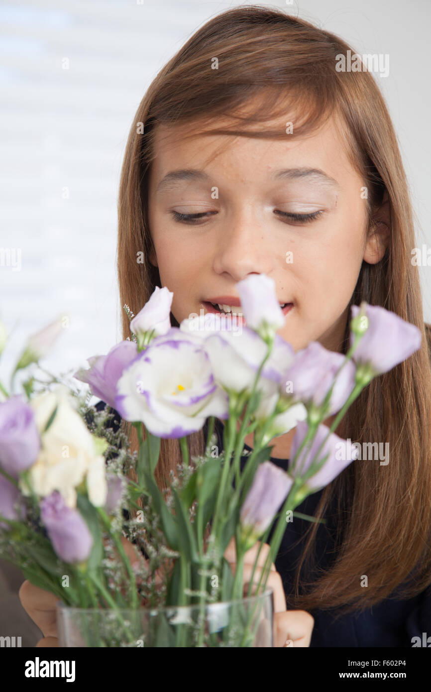 Pretty girl smelling the flowers Stock Photo - Alamy