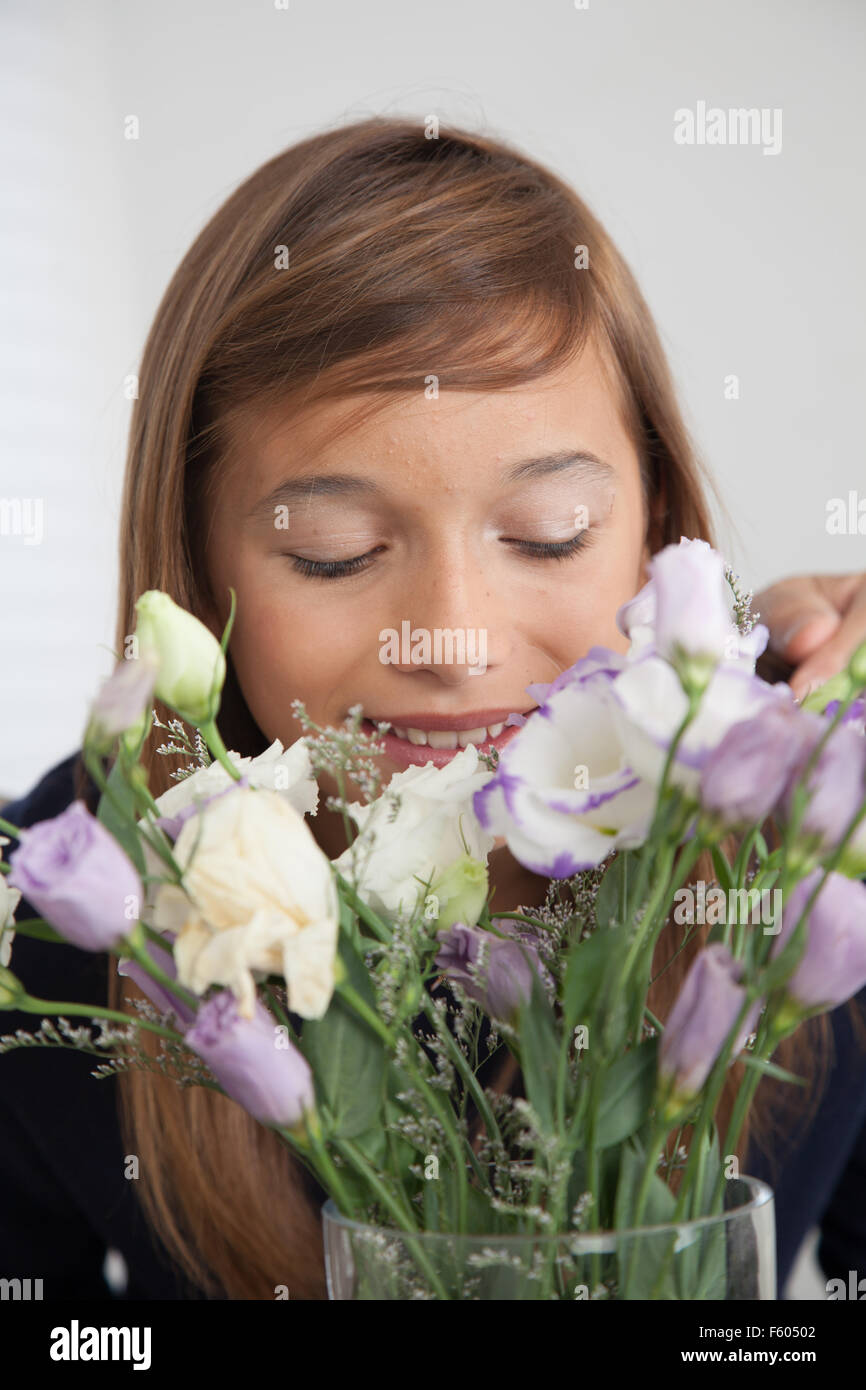 Pretty girl smelling the flowers Stock Photo - Alamy