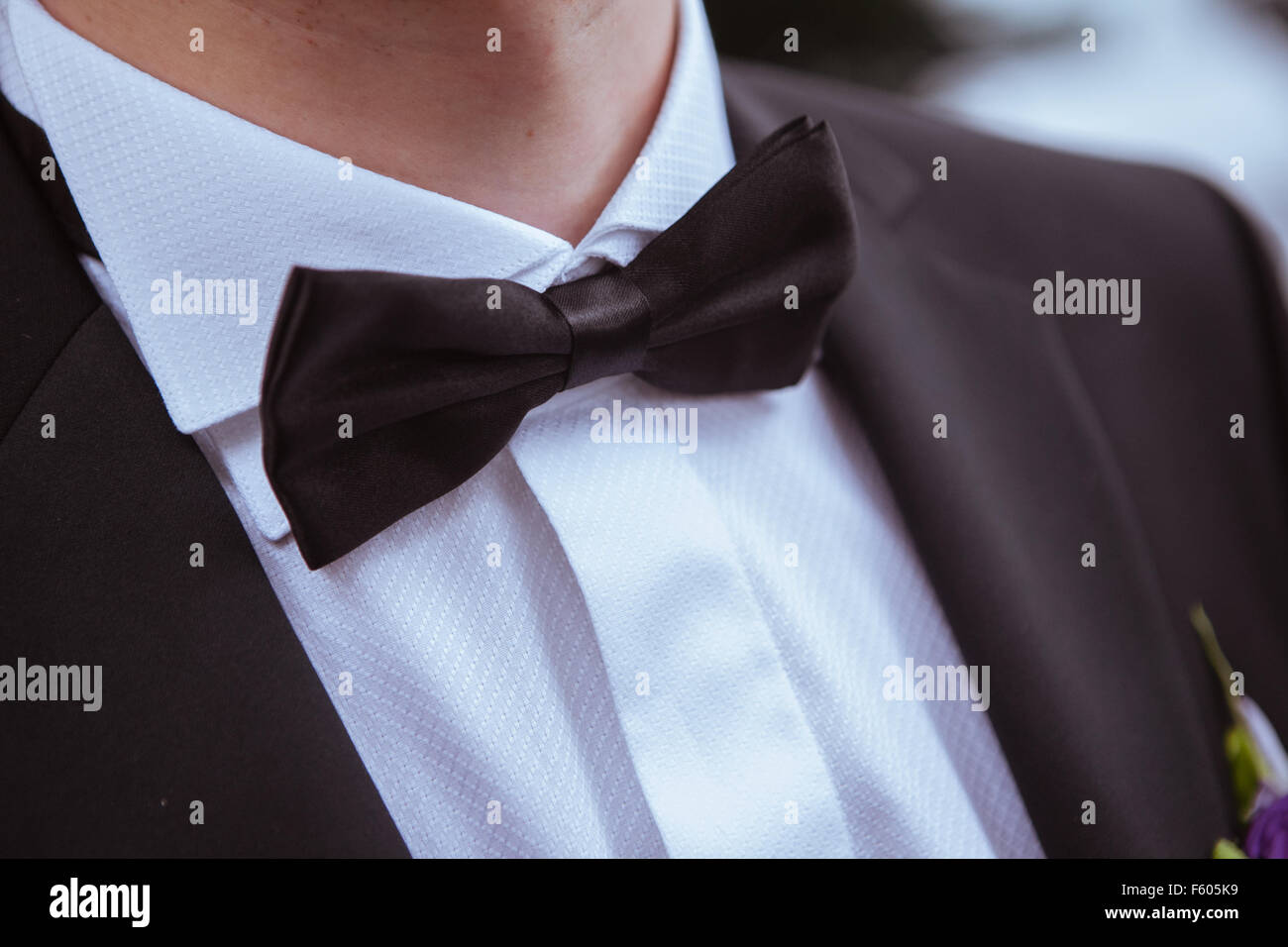 the groom wore a black tuxedo, white shirt and black bow tie Stock ...
