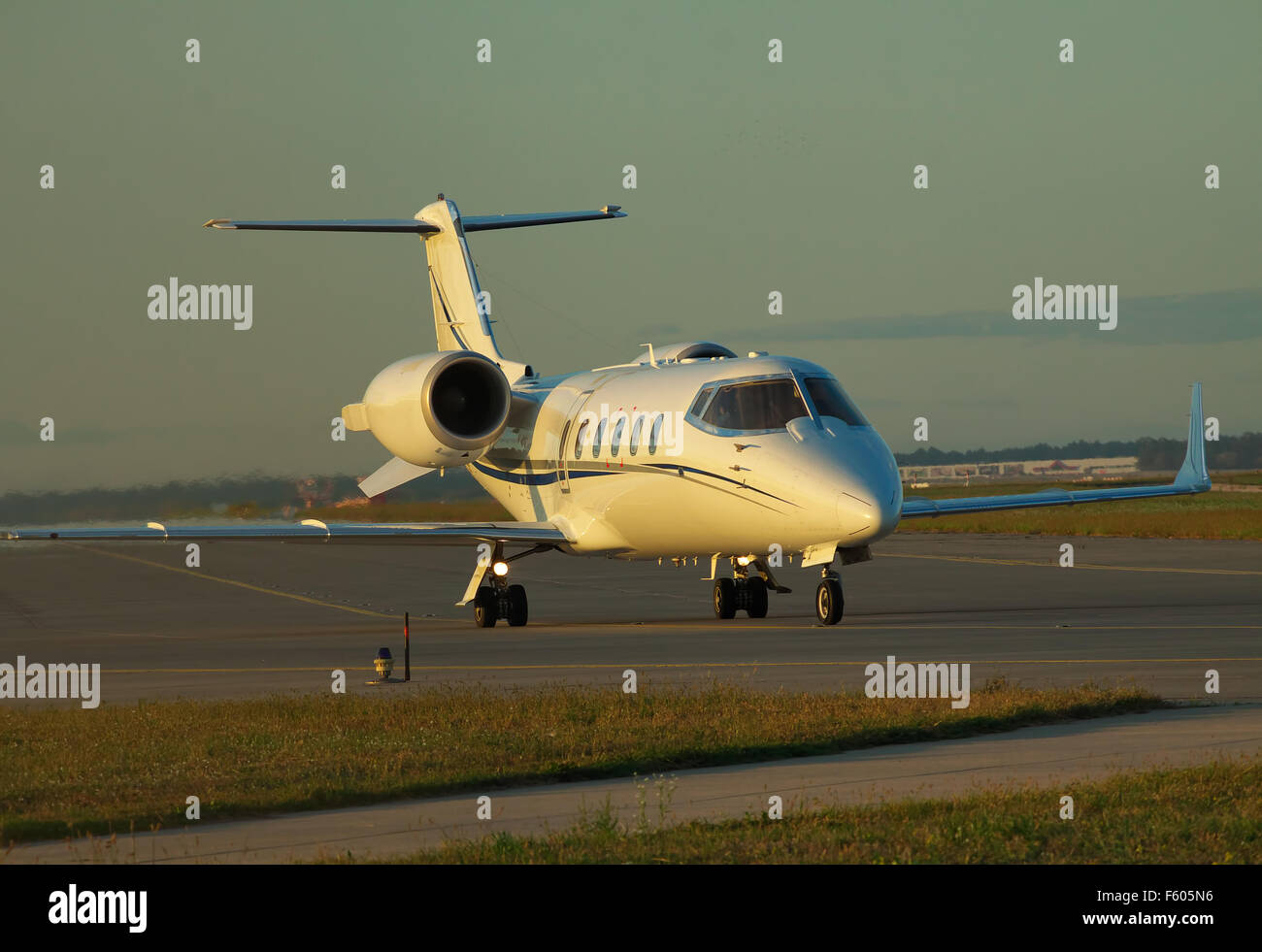Private business jet taxiing to the runway on sunset Stock Photo - Alamy