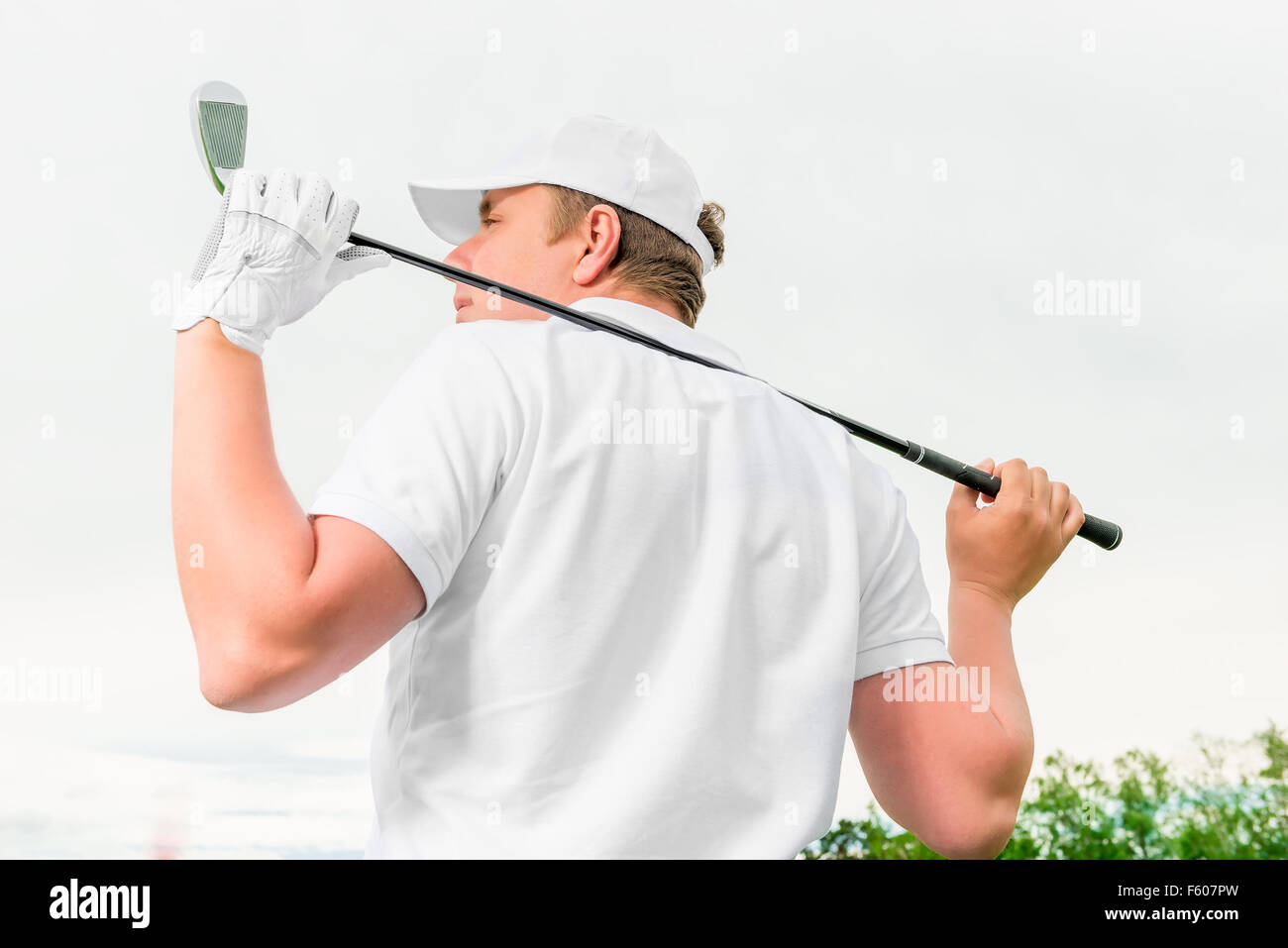 man holding a golf club behind his back Stock Photo - Alamy