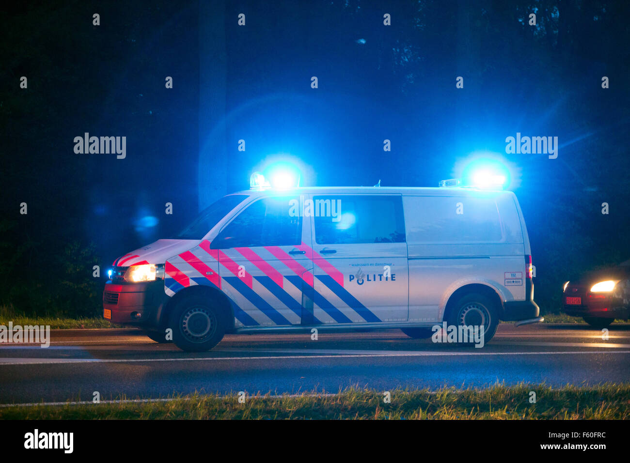 Dutch police car with emergency lights holding traffic during a car ...