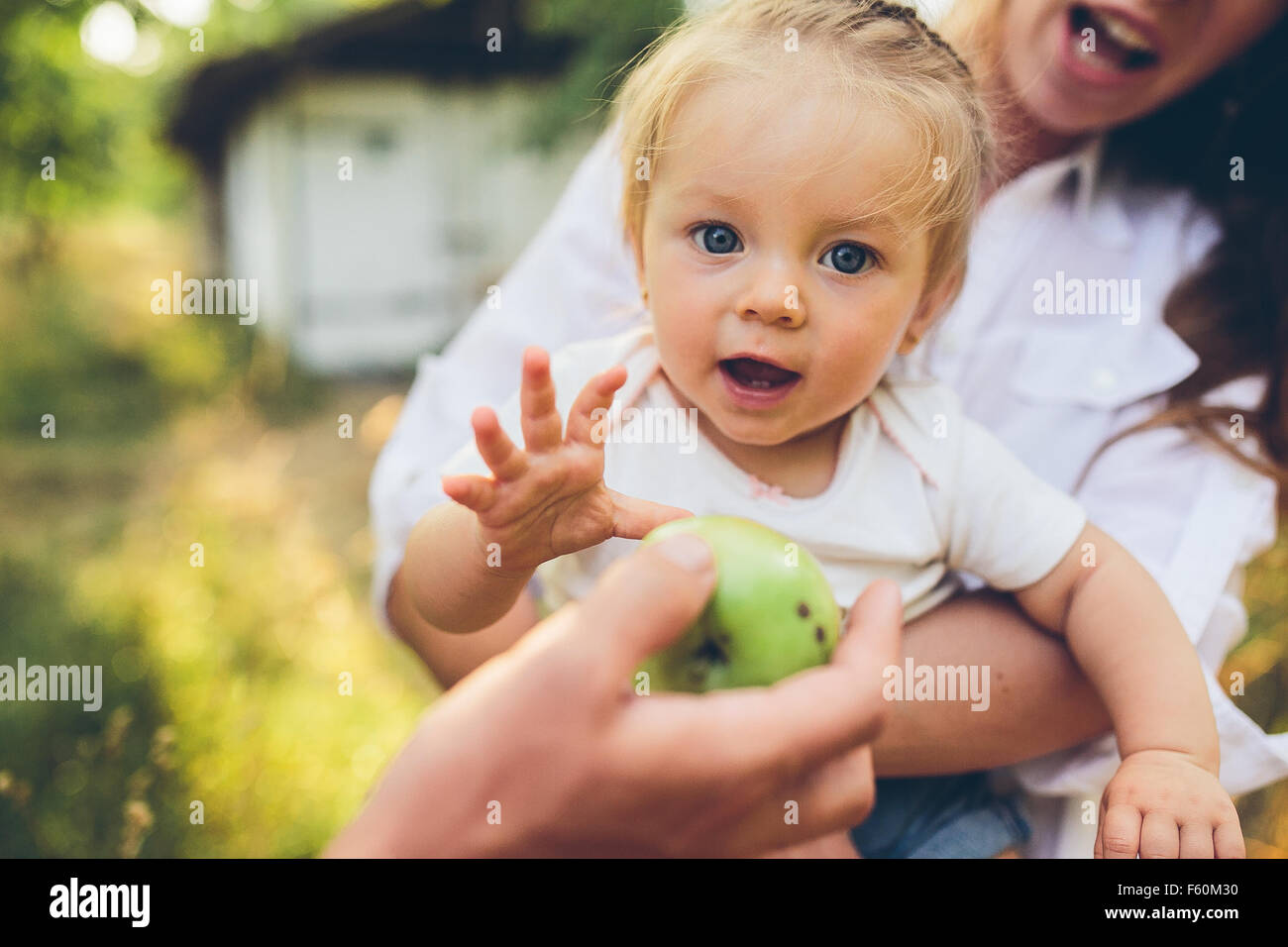Happy young mother and lovely daughter holding apple Stock Photo - Alamy