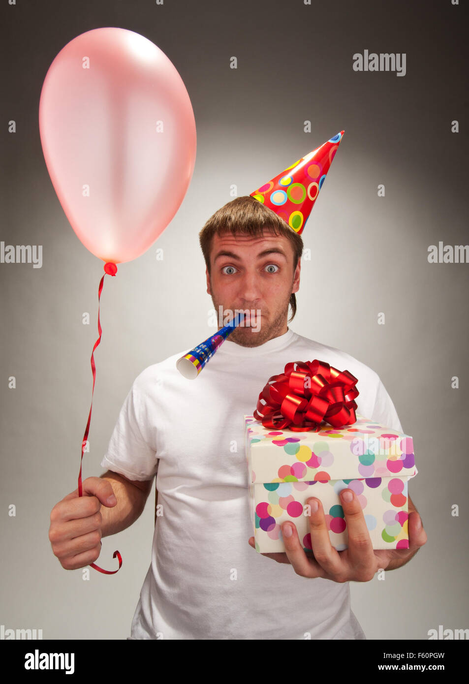 Young man celebrating birthday with gift and balloon Stock Photo - Alamy