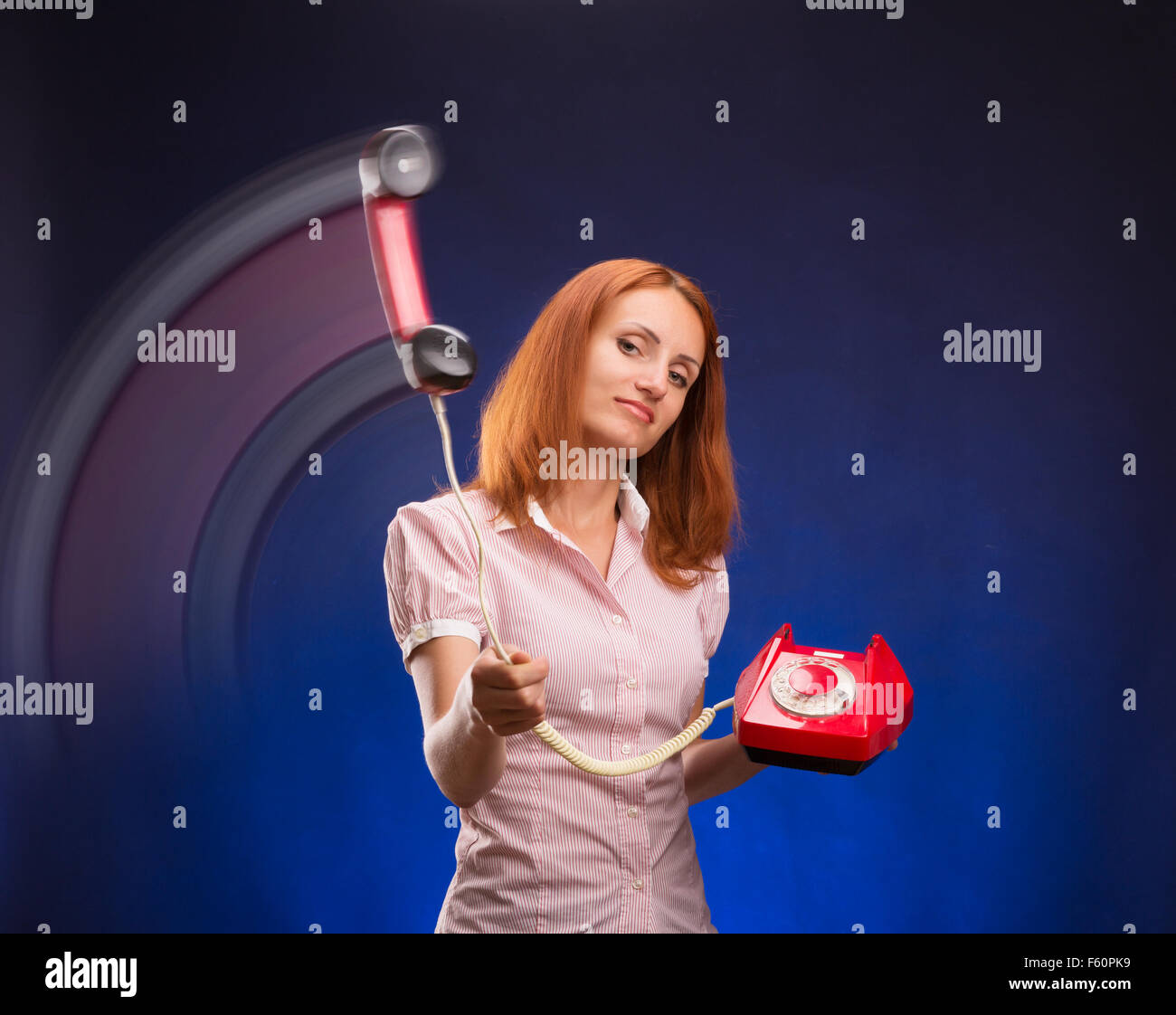 Redhead woman is spinning red telephone Stock Photo - Alamy
