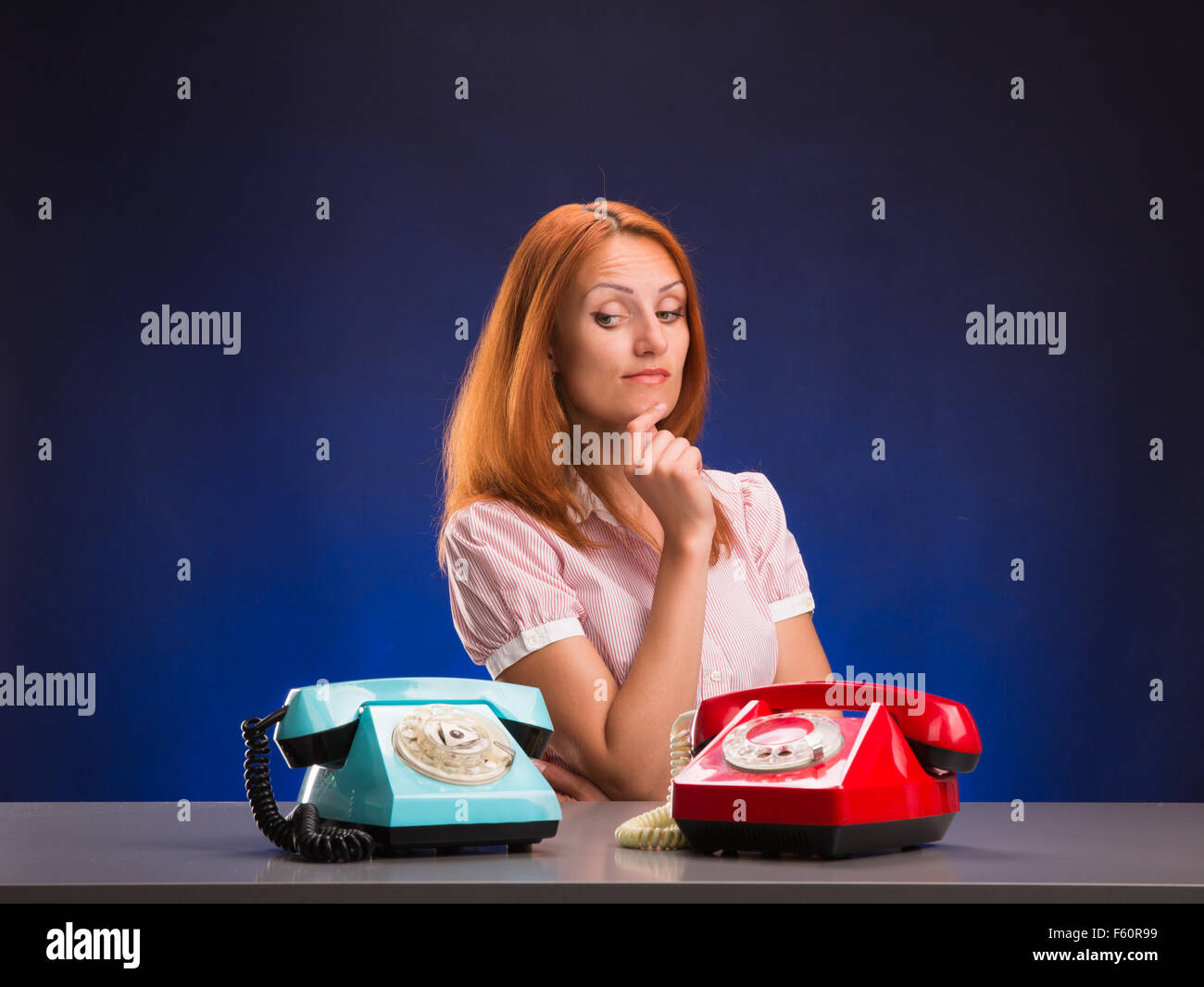 Redhead woman with two phones Stock Photo - Alamy