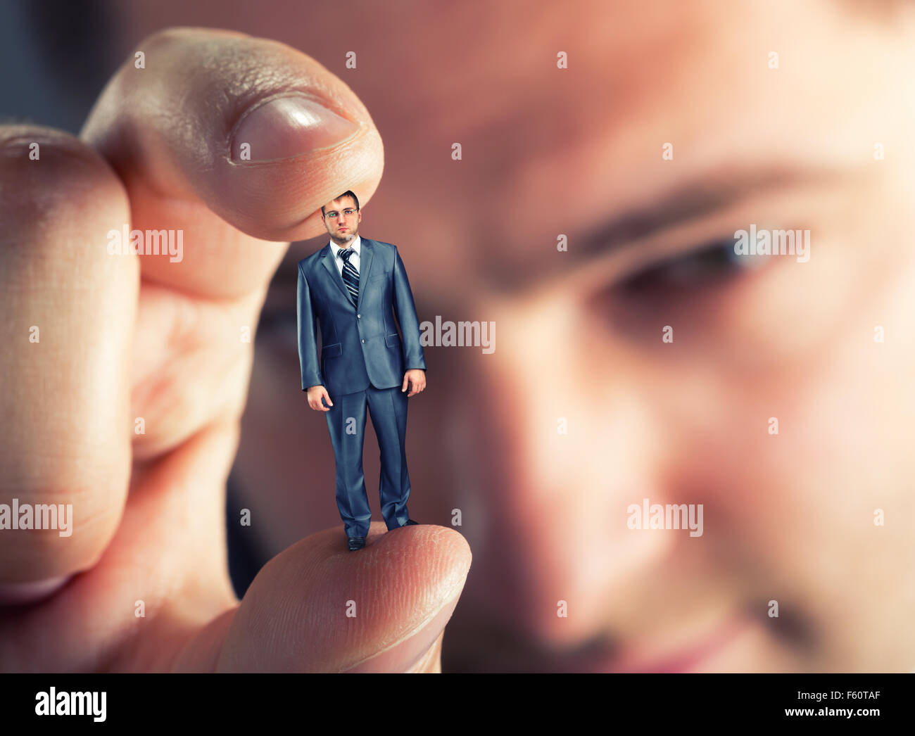 Big boss looking at small businessman in hand Stock Photo - Alamy