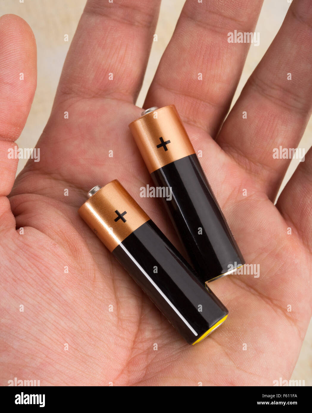 Two batteries in palm of hand Stock Photo - Alamy