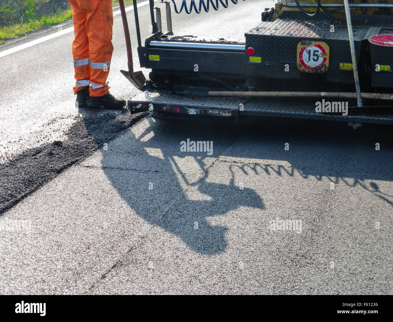 Workers spread asphalt on a hot summer day Stock Photo - Alamy
