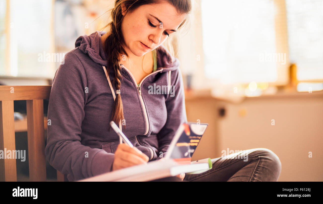 Teenage girl sitting in her bedroom doing her homework Stock Photo - Alamy