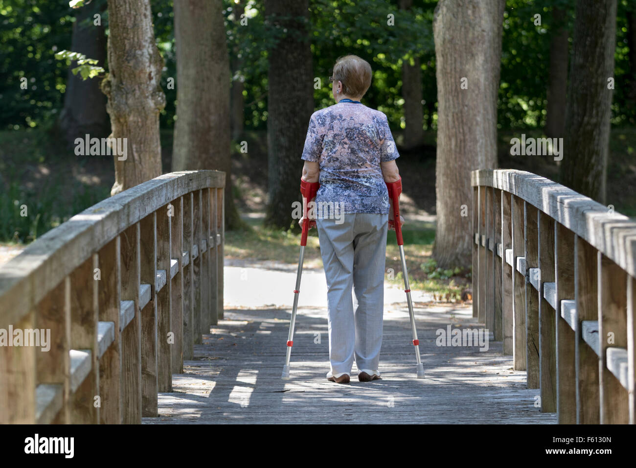 Elderly woman walking with crutches, Germany Stock Photo - Alamy