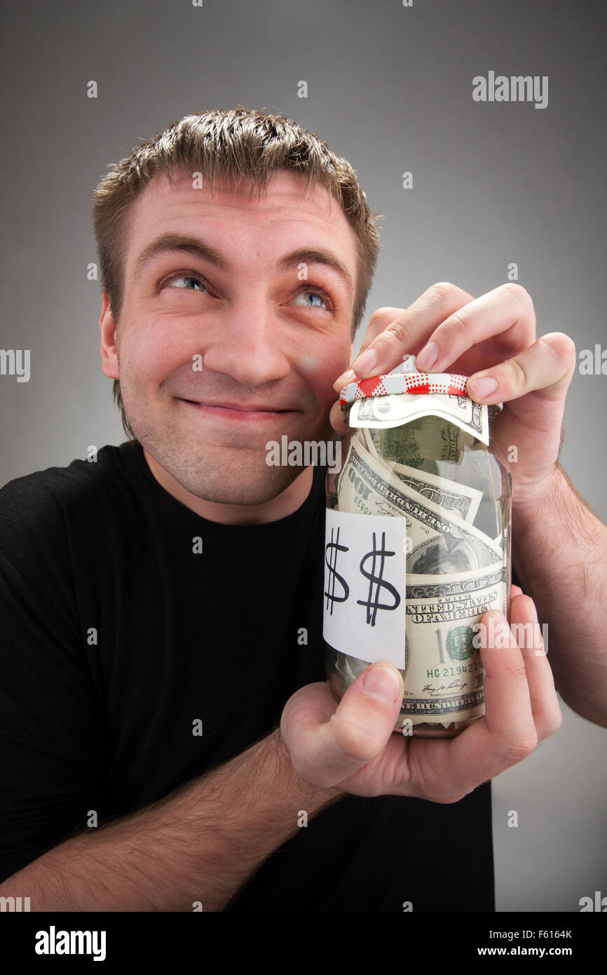 Portrait of happy man with canned money Stock Photo - Alamy