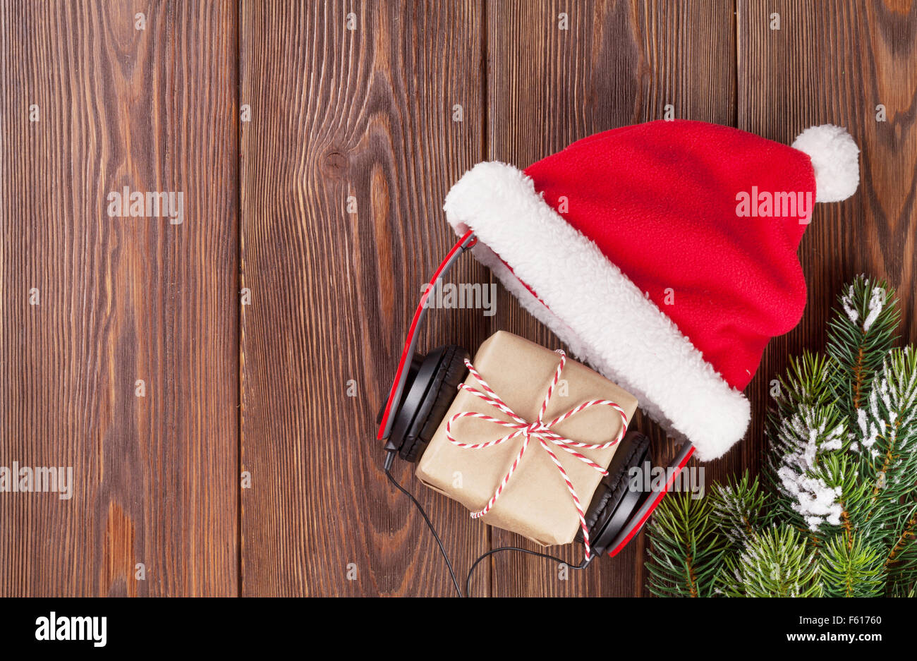 Christmas gift box with headphones and santa hat on wooden table. Top ...