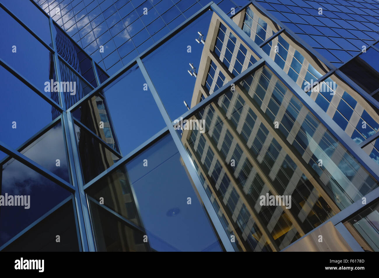 A skyscraper is reflected in the side of another skyscraper in the ...