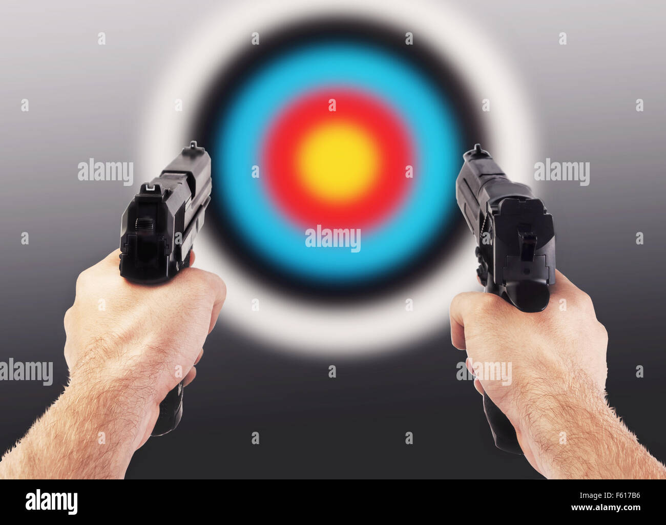 Hands with two guns against colourful shooting target Stock Photo - Alamy
