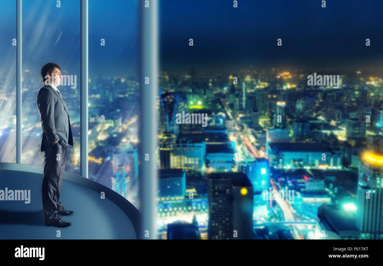 Businessman staying infront of big window with city view Stock Photo ...
