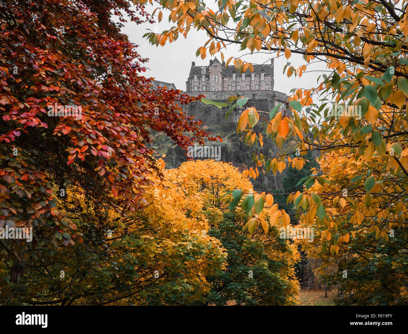 Edinburgh castle through the autumn trees in Princes Street Gardens ...