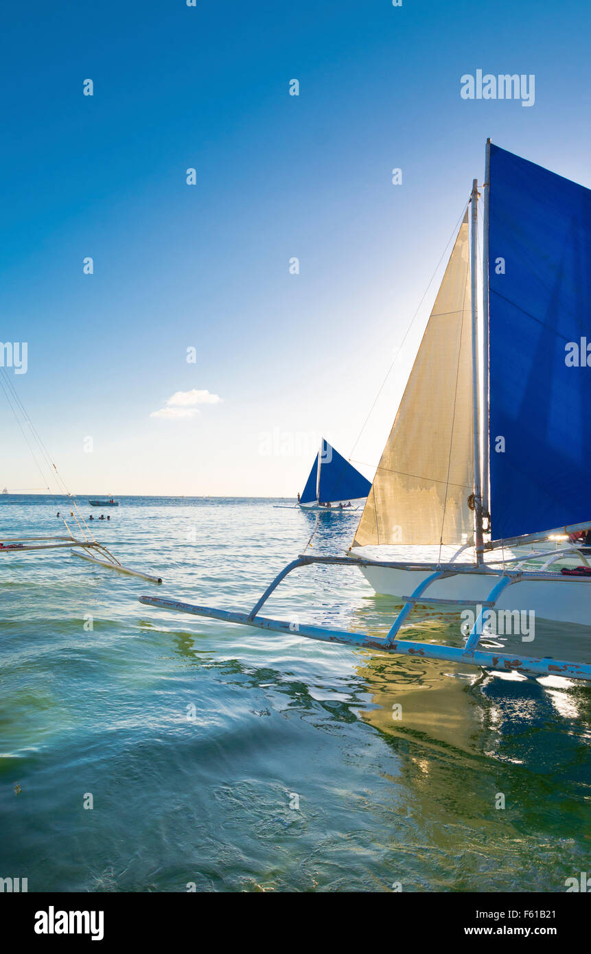 traditional paraw sailing boats on white beach on boracay island ...