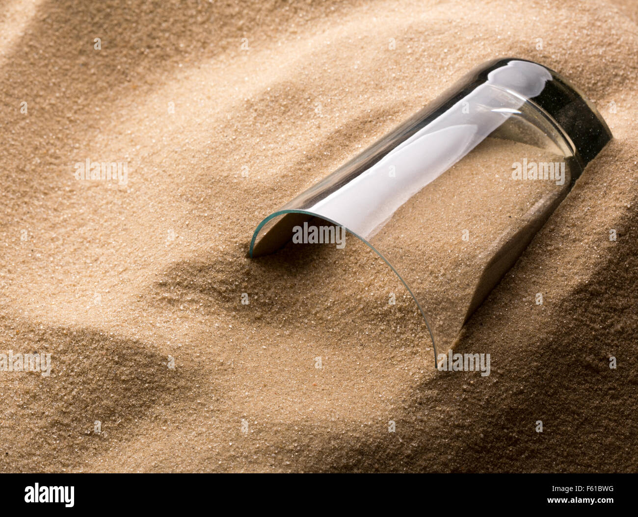 Closeup of empty glass in sand Stock Photo - Alamy
