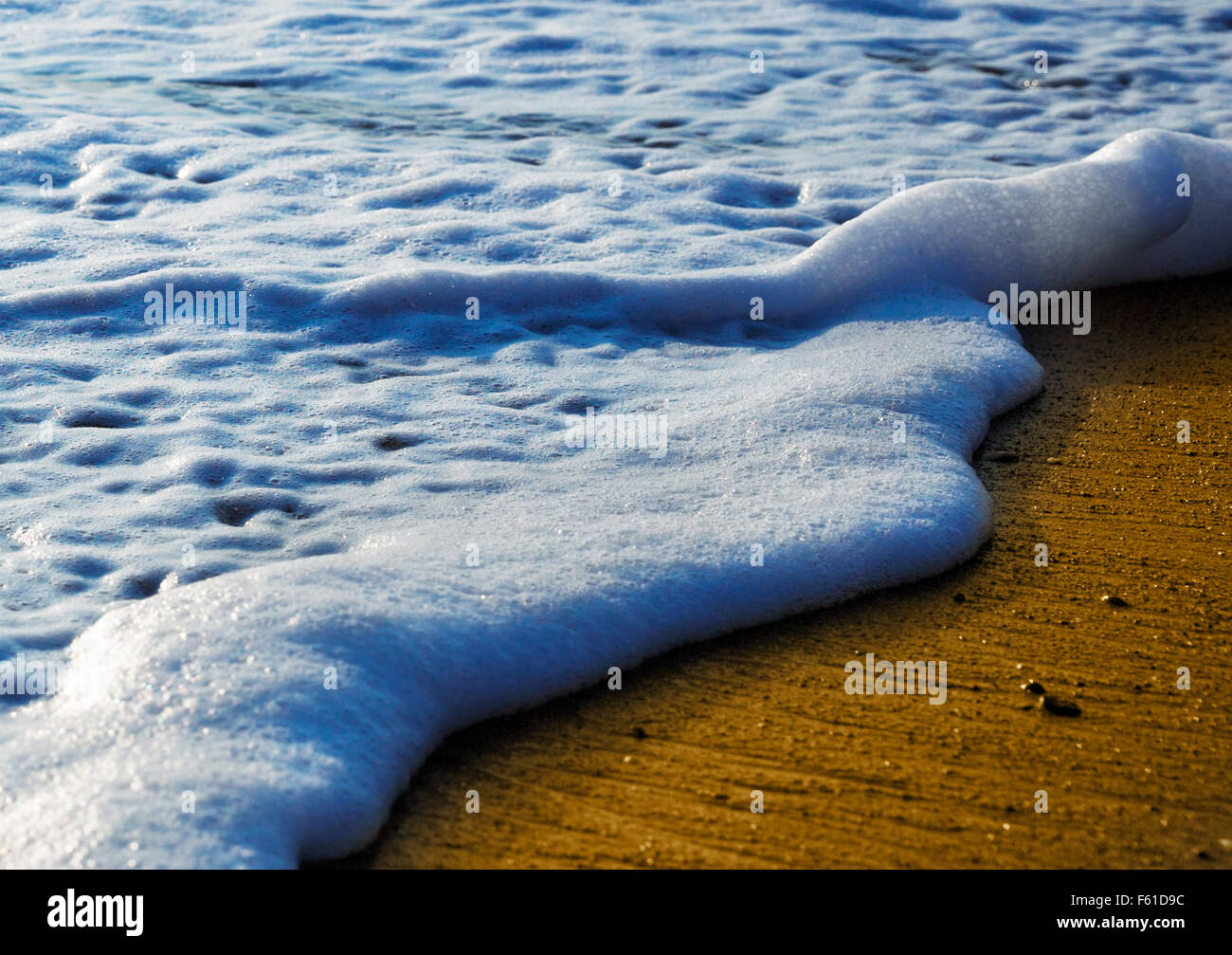 Closeup of small waves on the beach Stock Photo - Alamy