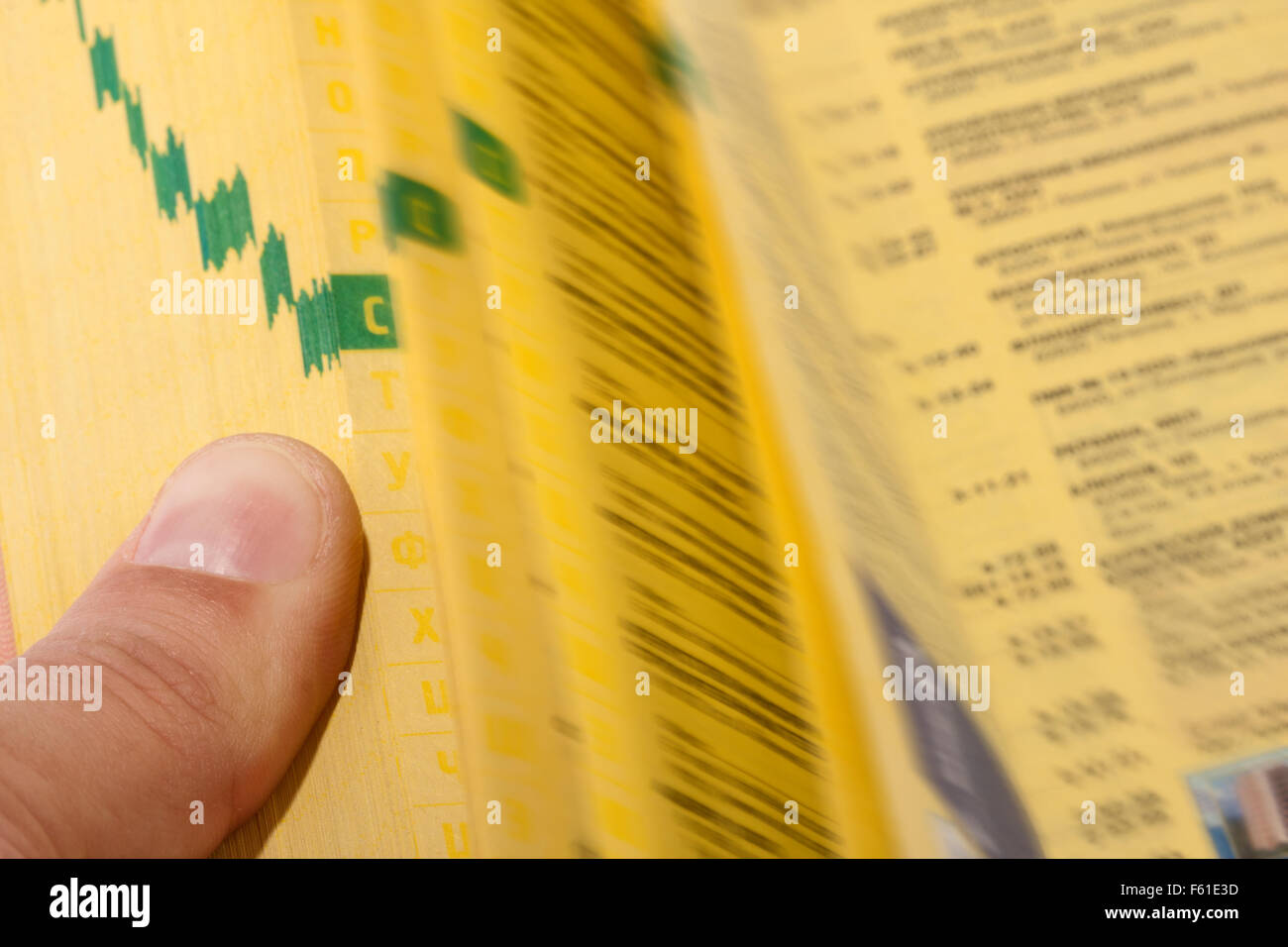 Hand searching the yellow pages with index finger Stock Photo - Alamy